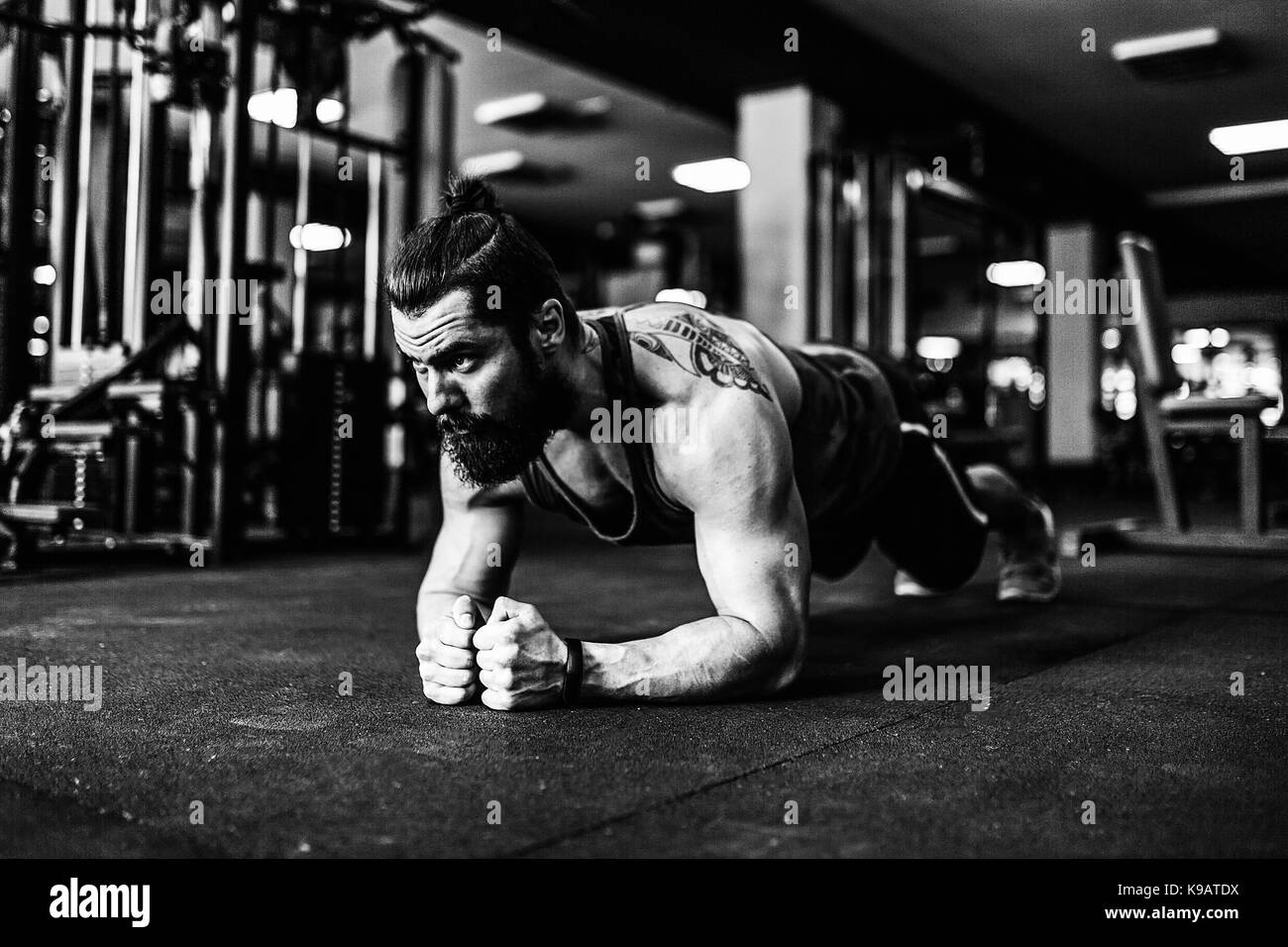 Muscled young man wearing sport wear and doing plank position while ...
