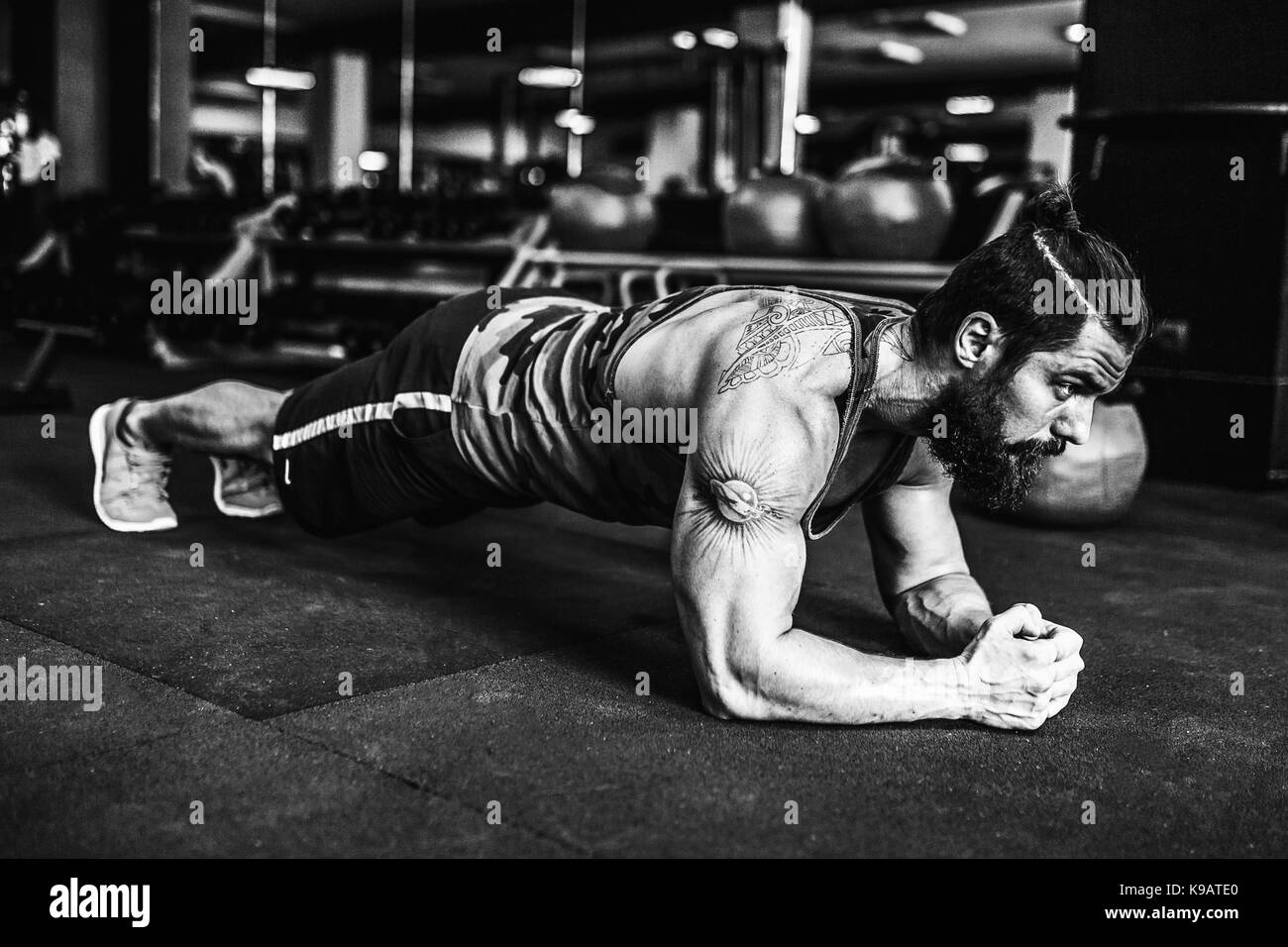 Muscled young man wearing sport wear and doing plank position while ...