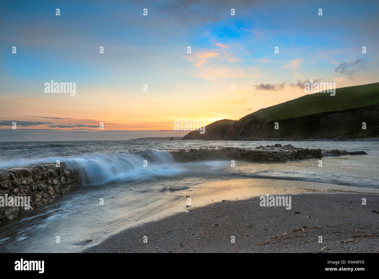 Waves wash over the sea wall at Portwrinkle in SE Cornwall at high tide ...
