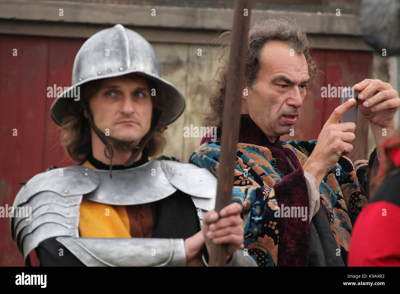 Background actor takes a picture using a smart phone next to another ...