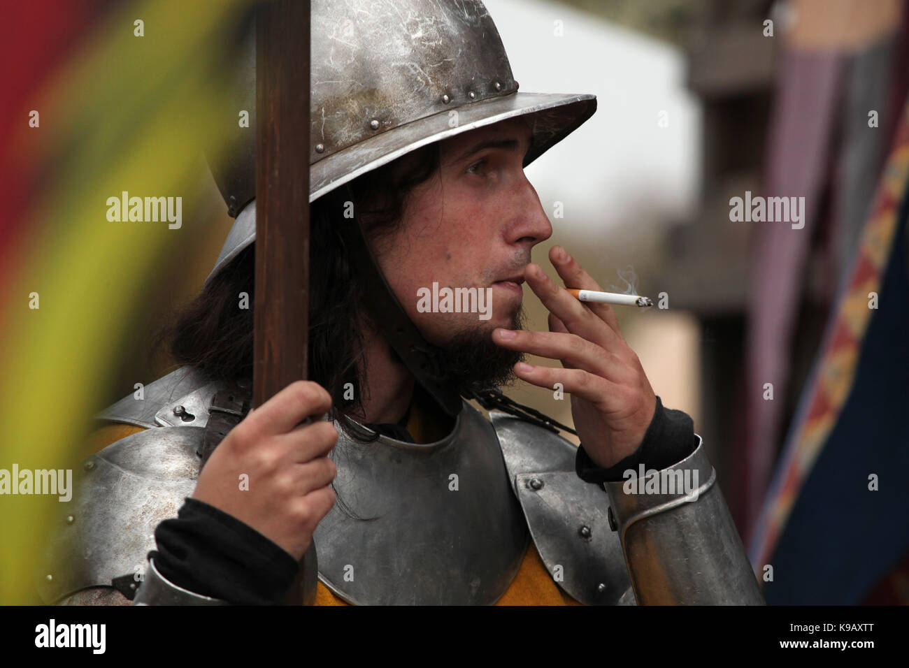 Background actor Adam Průcha dressed as a medieval guard smokes a ...