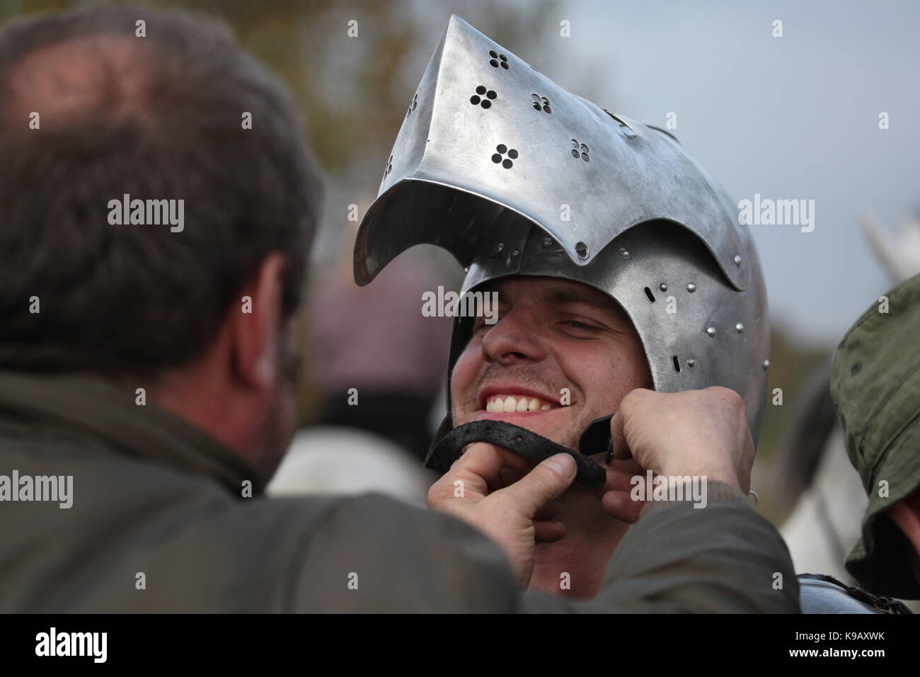 Staff member fixes medieval armour on an actor dressed as a medieval ...