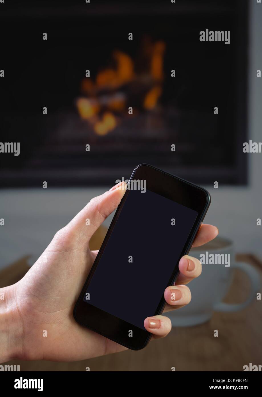 Digital composite of Hand holding phone at home Stock Photo - Alamy
