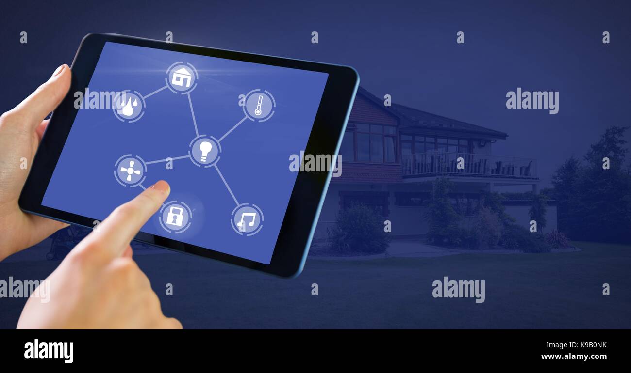 Digital composite of Hand holding tablet with smart home interface at ...