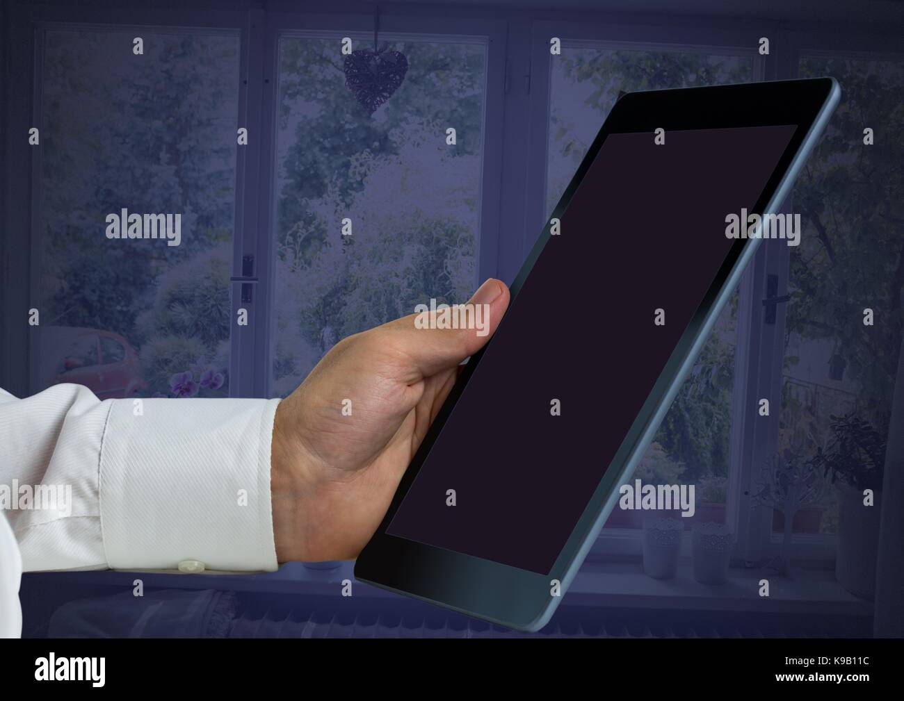 Digital composite of Hand holding tablet at home Stock Photo - Alamy