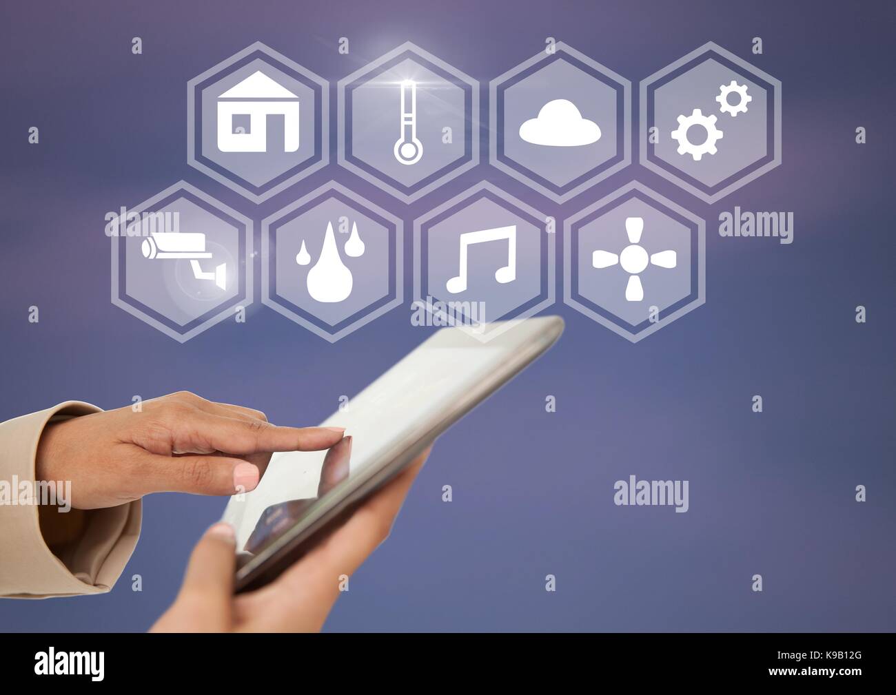 Digital composite of Hand holding tablet with smart home interface at ...