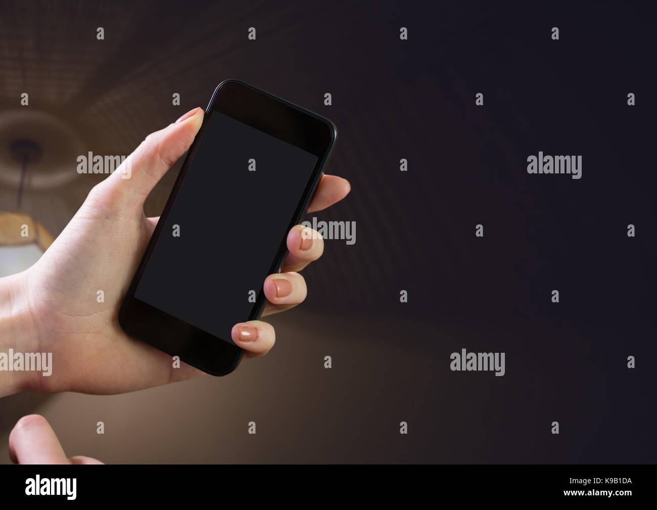 Digital composite of Hand holding phone at home Stock Photo - Alamy