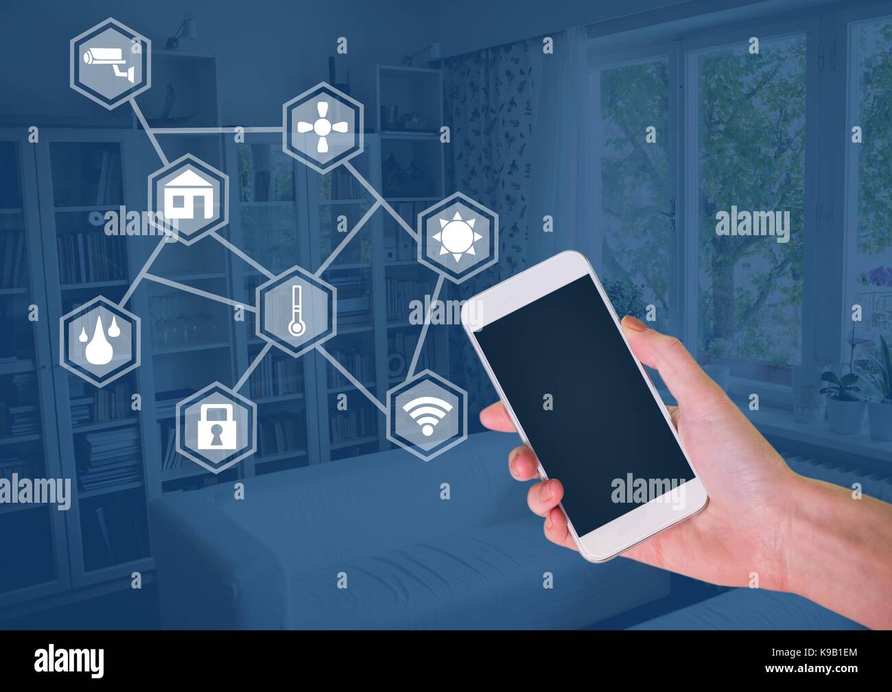 Digital composite of Hand holding phone with smart home interface at ...