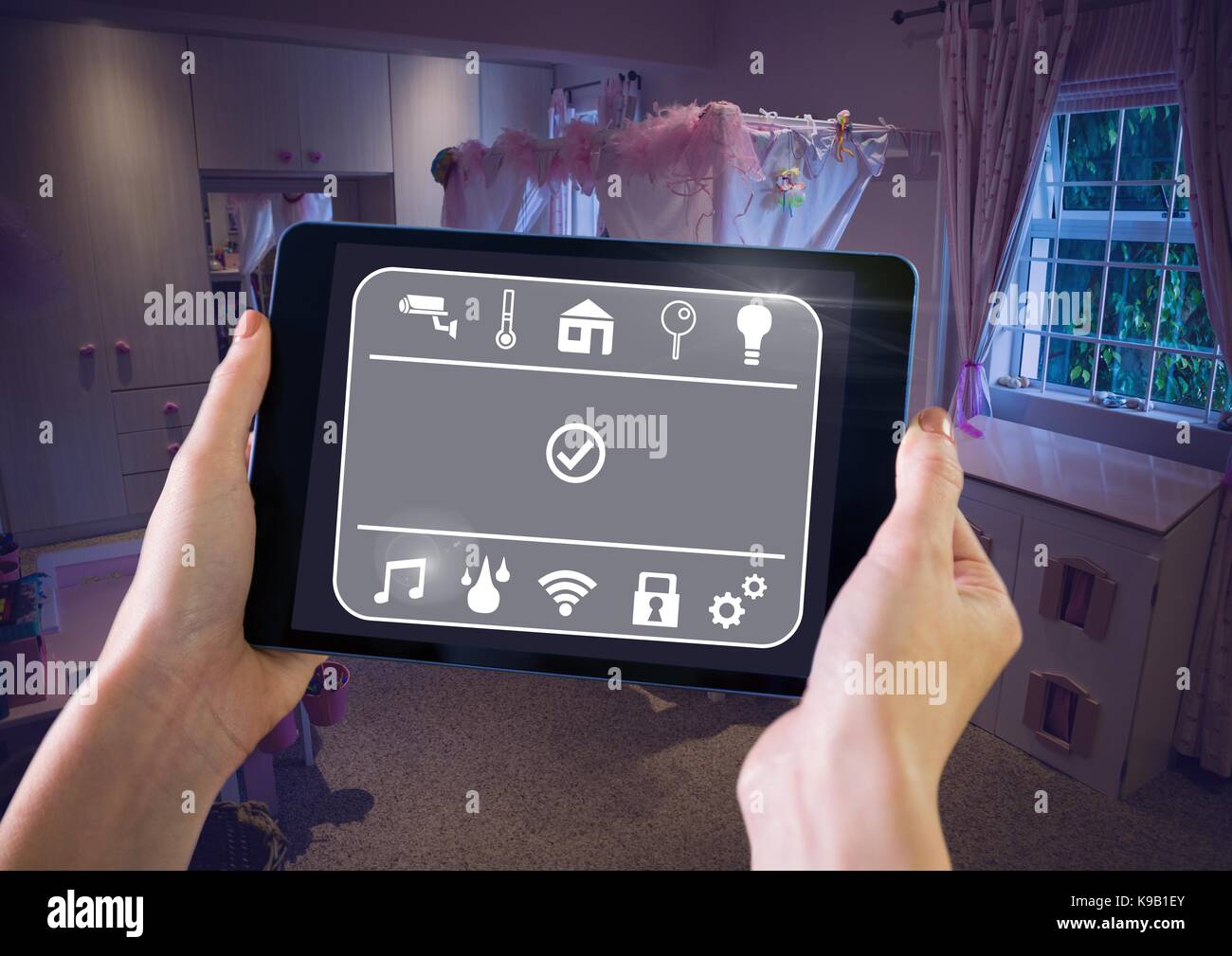 Digital composite of Hand holding tablet with smart home interface at ...