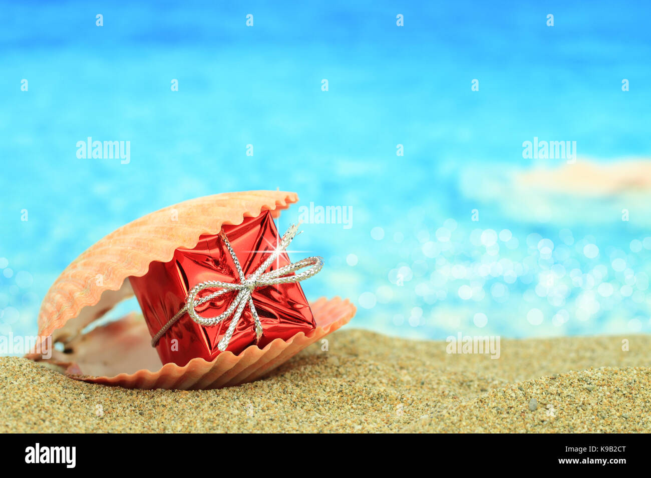 Gift box in a sea shell on the beach Stock Photo - Alamy