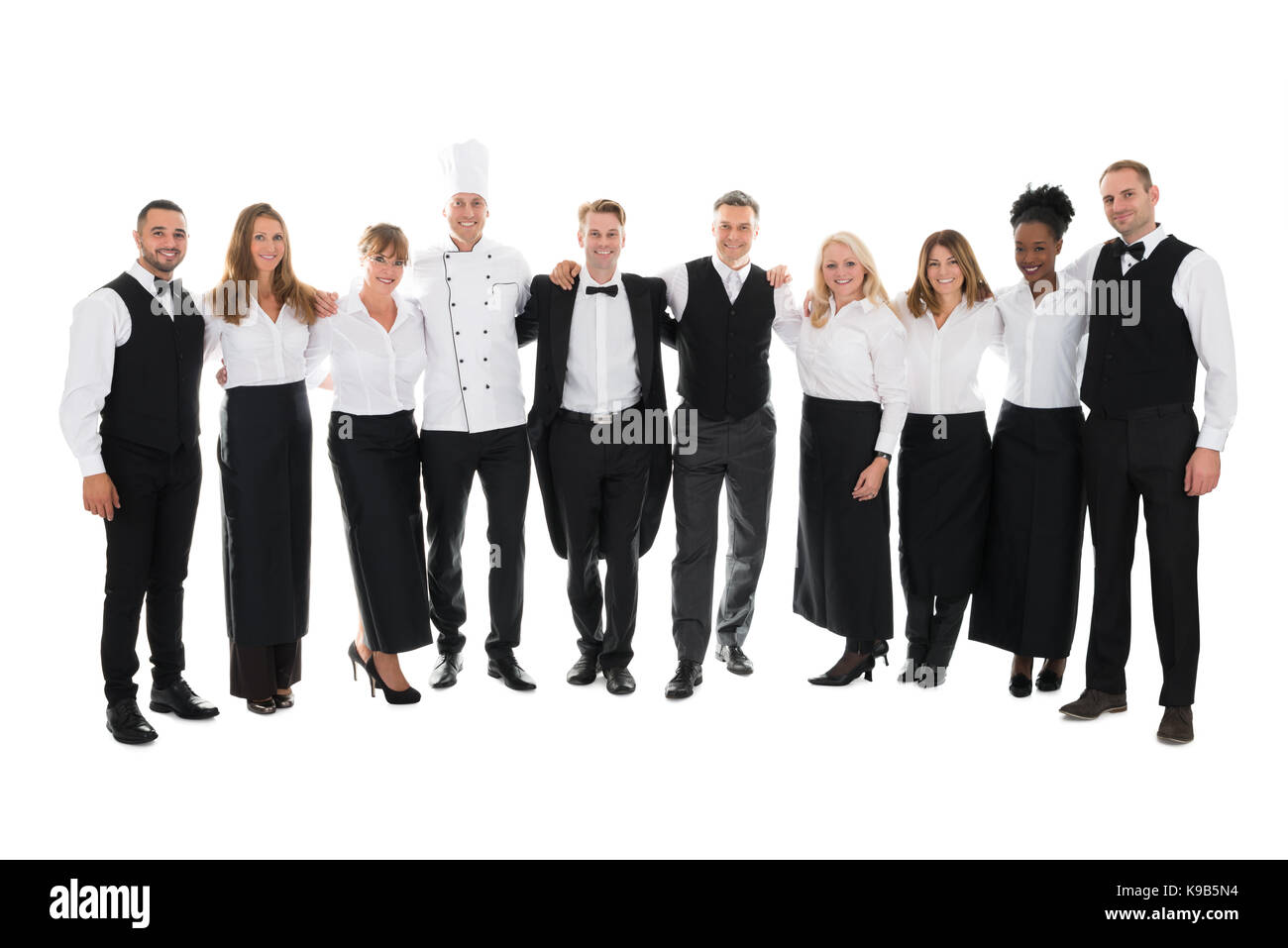 Full length portrait of confident restaurant staff standing with arms ...