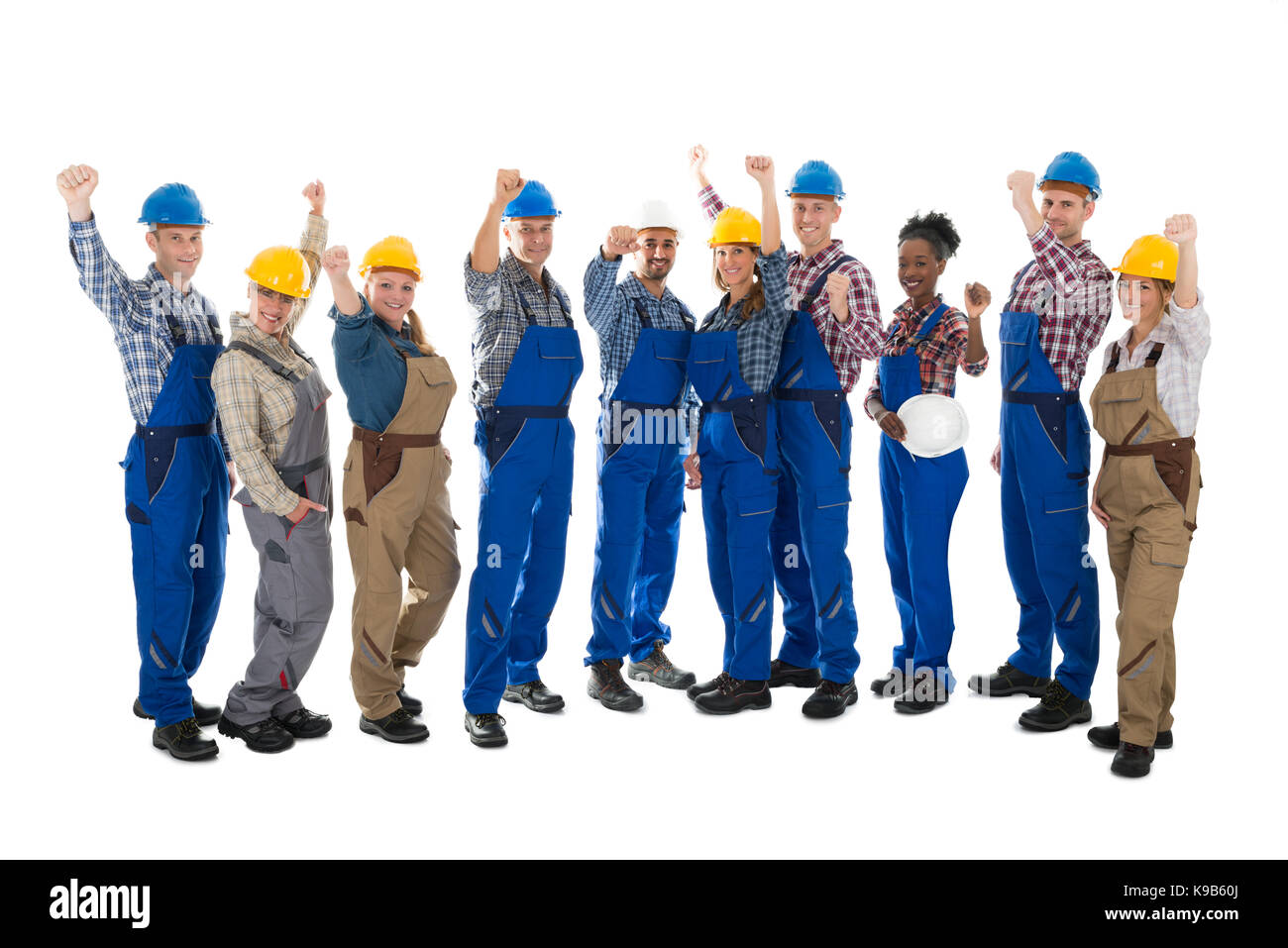 Full length portrait of happy carpenters standing with arms raised ...