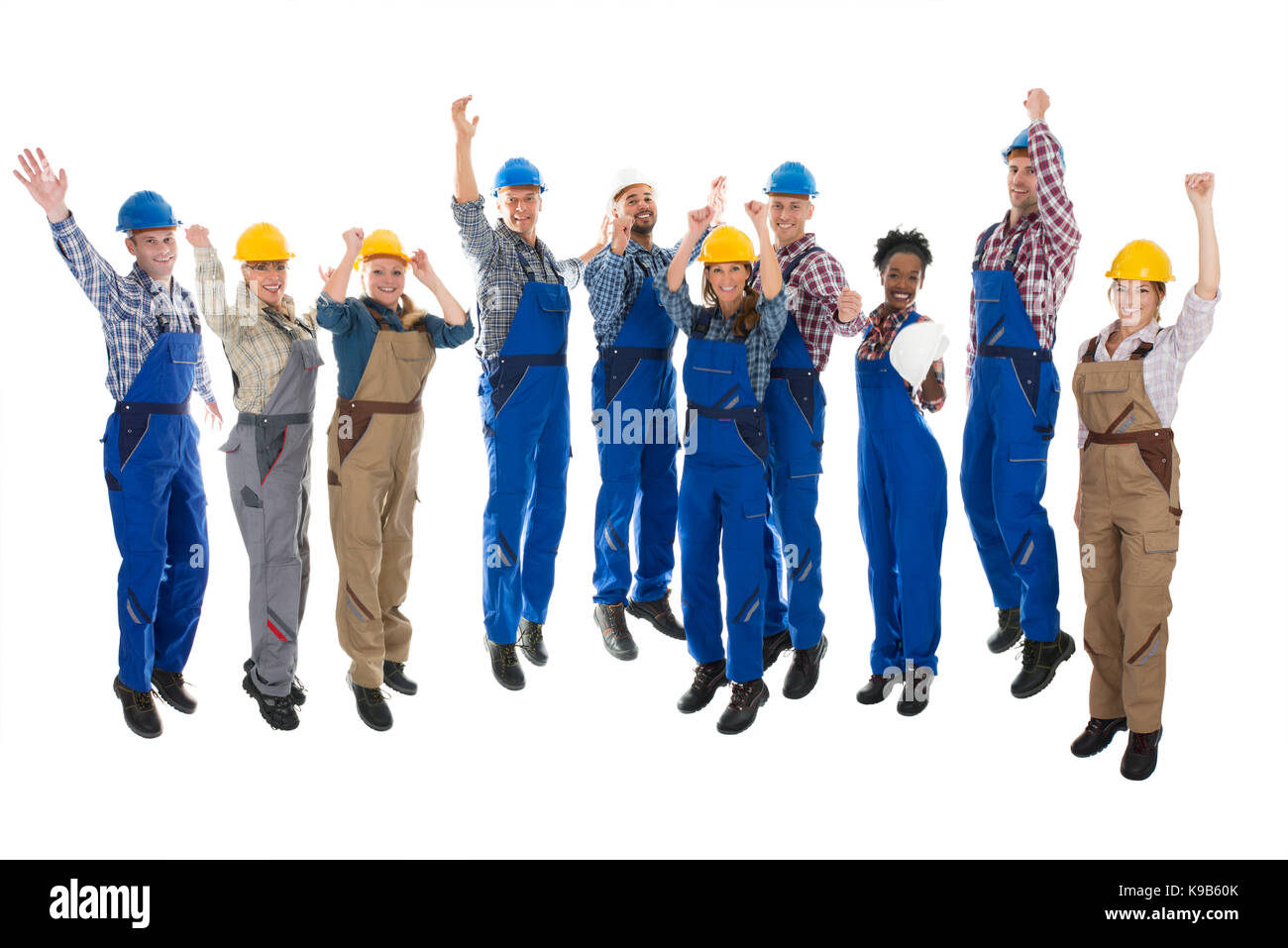Full length portrait of happy carpenters standing with arms raised ...