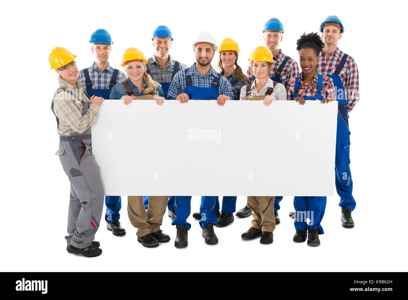 Portrait of happy construction workers holding blank billboard against ... Portrait of happy construction workers holding blank billboard against ...