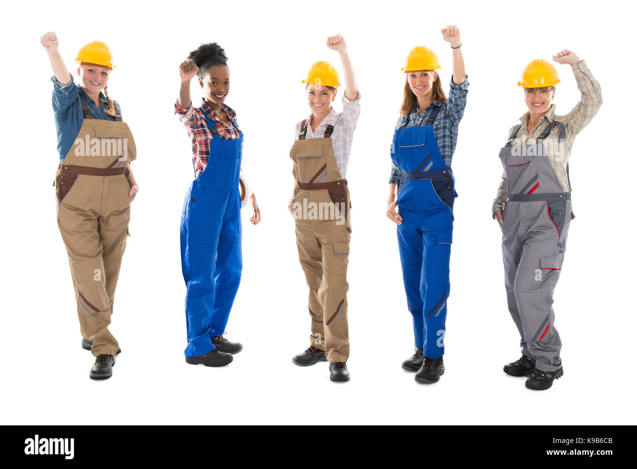 Full length portrait of successful female carpenters with arms raised ...