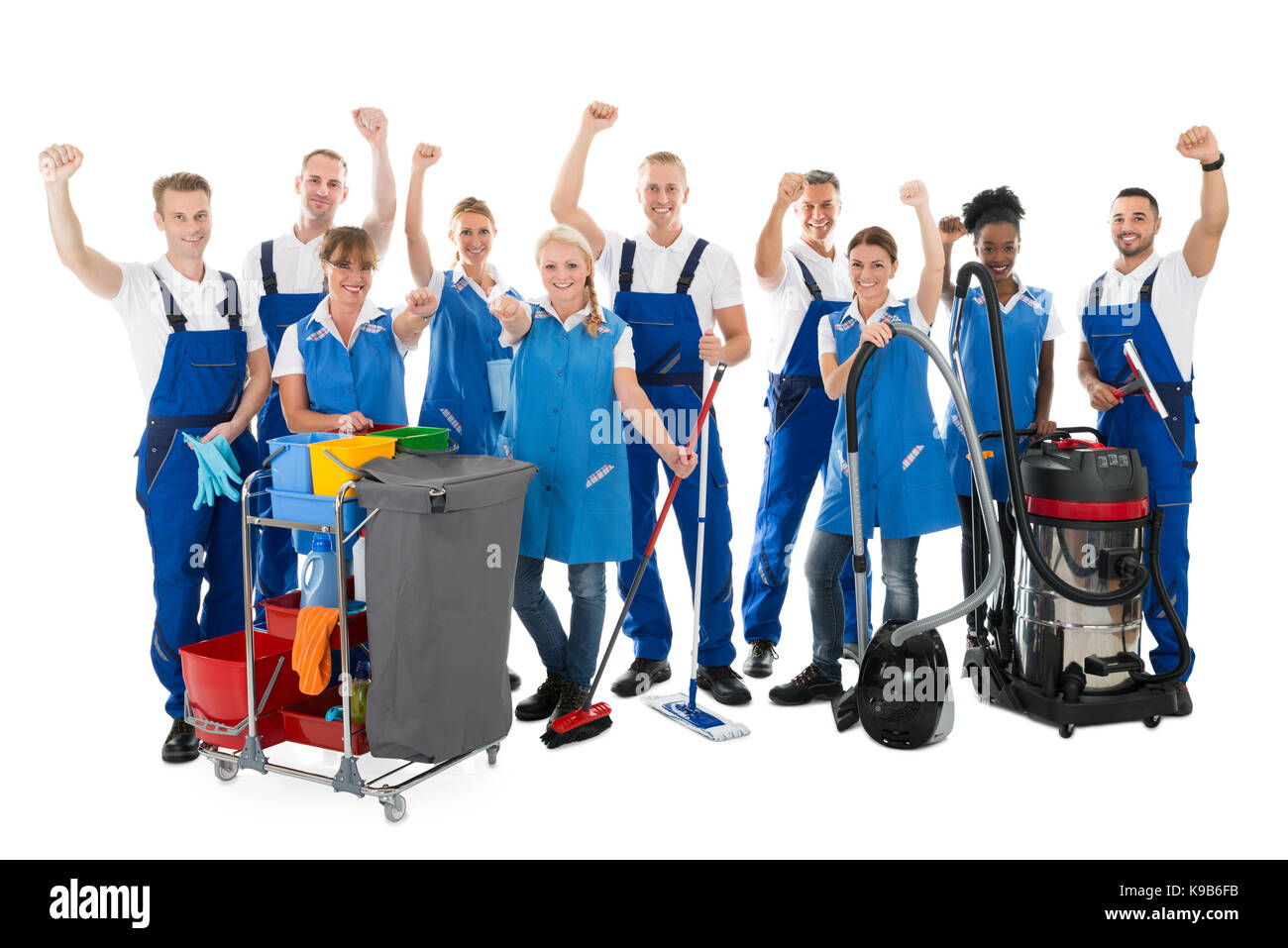 Portrait of happy multiethnic janitors with arms raised holding ...