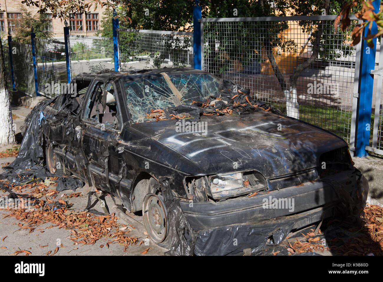 Discarded old car next to the fence Stock Photo - Alamy