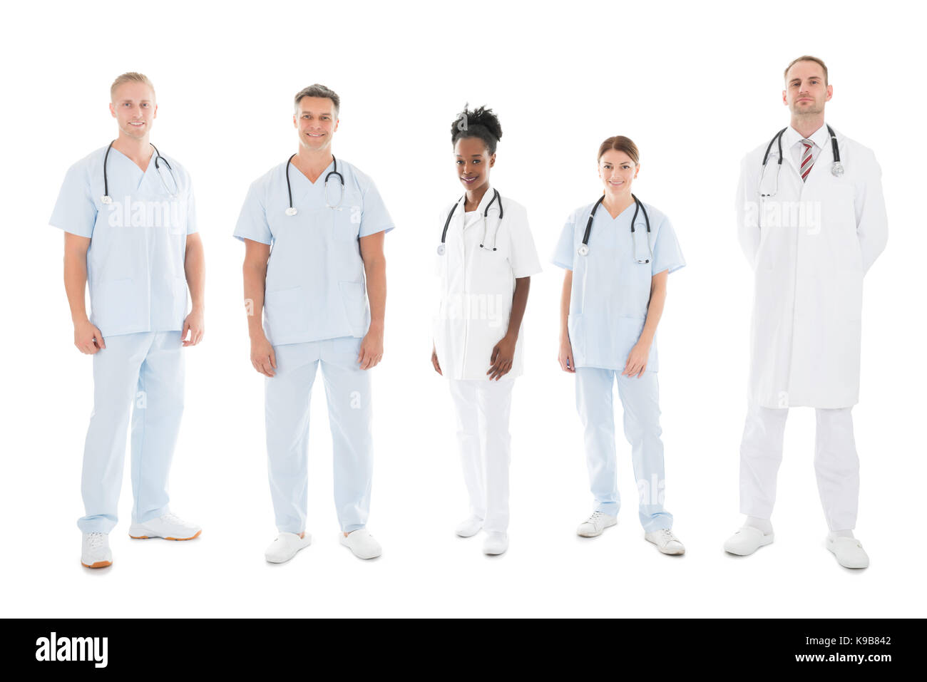 Full length portrait of confident multiethnic medical team standing in ...