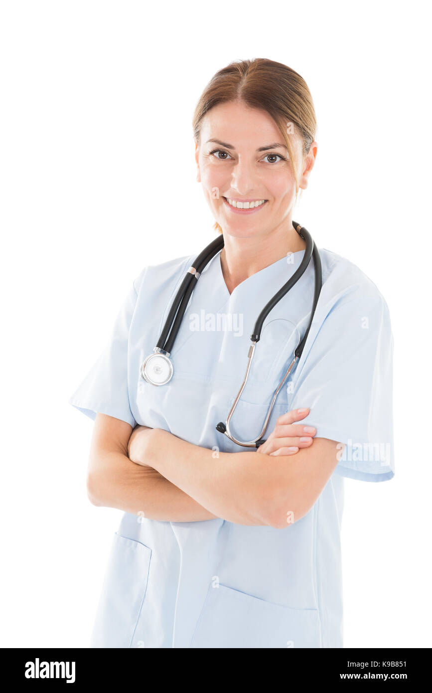 Portrait Of Happy Female Doctor Standing Arms Crossed Against White