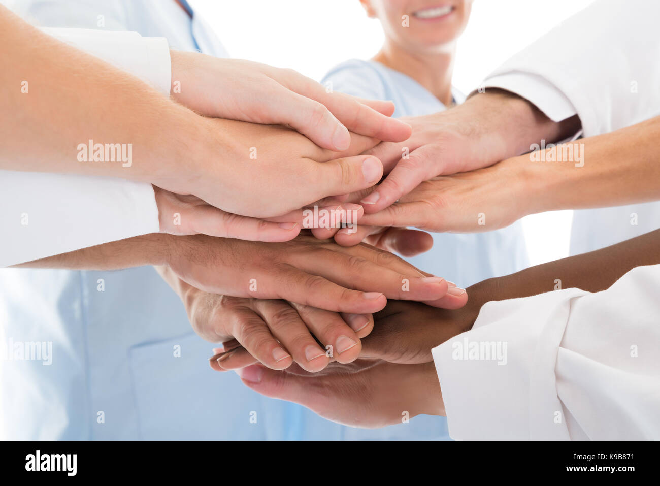 Cropped image of medical team stacking hands against white background ...
