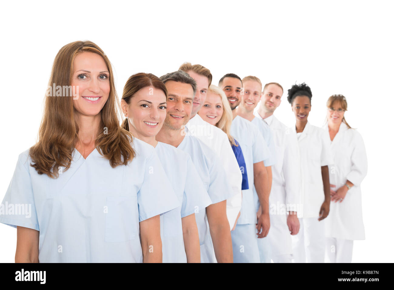 Portrait of smiling multiethnic medical team standing in line against ...