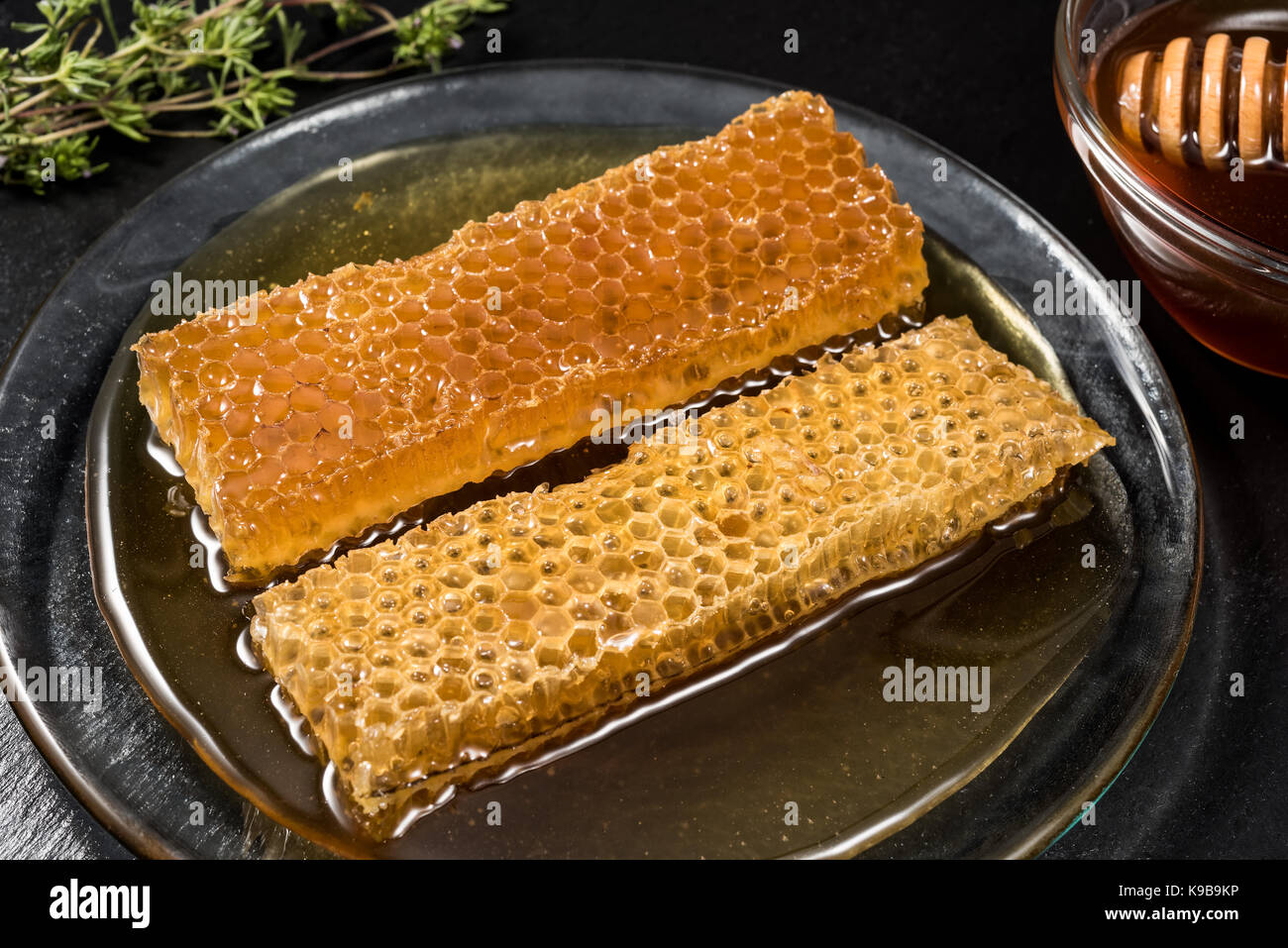 Honey and honeycomb on black dish Stock Photo - Alamy