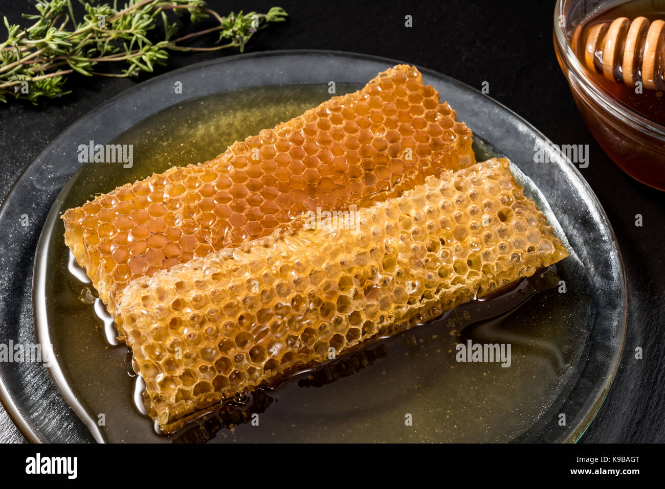 Honey and honeycomb on black dish Stock Photo - Alamy
