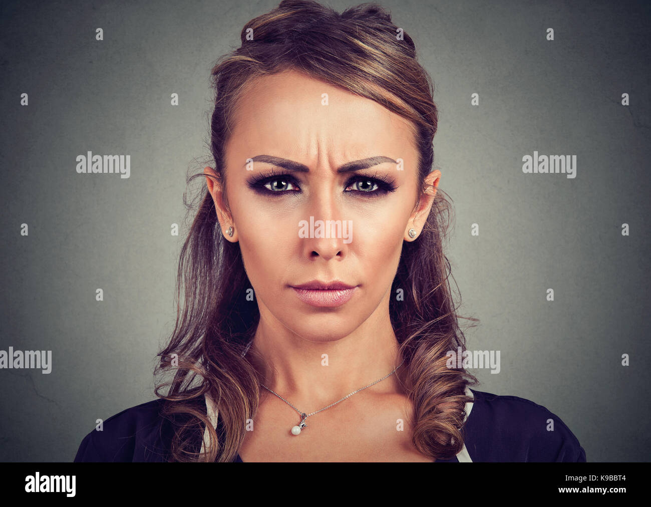 Young woman frowning looking at camera Stock Photo - Alamy