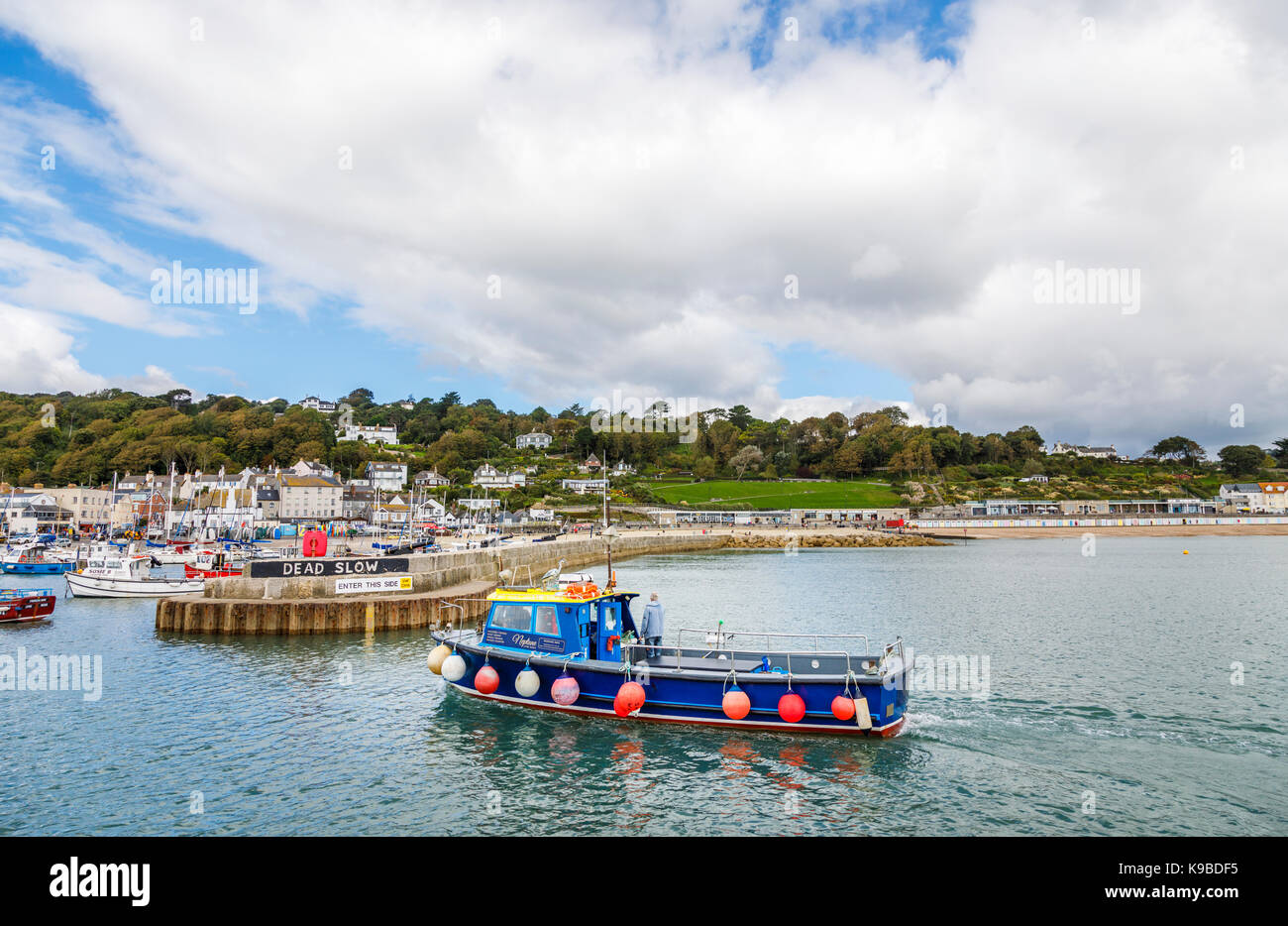Fishing boat approaches from Lyme Bay into Lyme Regis harbour a coastal ...