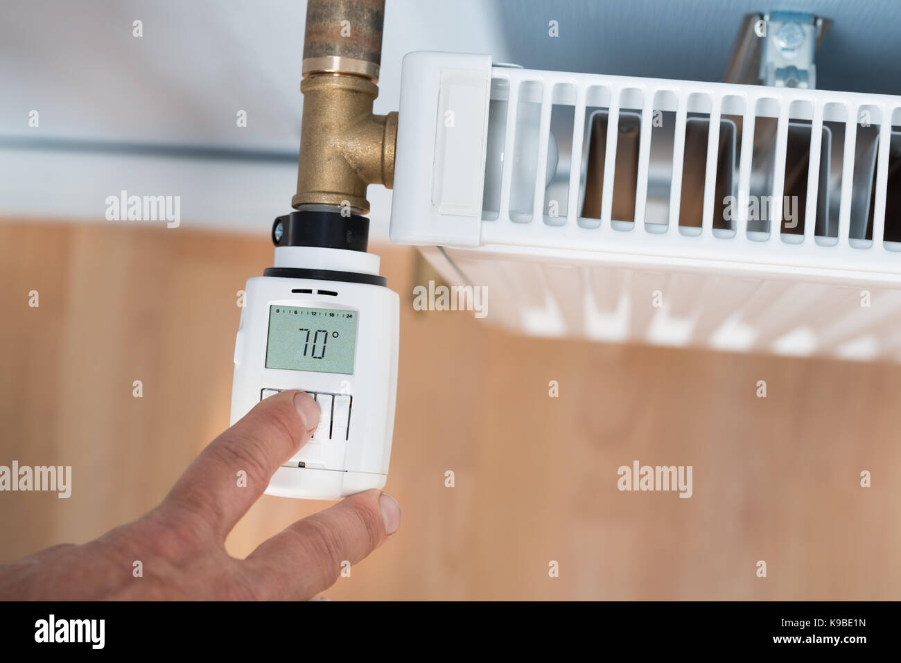 High Angle View Of Person's Hand Adjusting Temperature On Thermostat ...