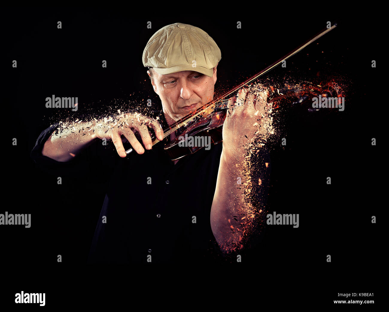 Portrait of a man playing wooden violin shattering on black background ...
