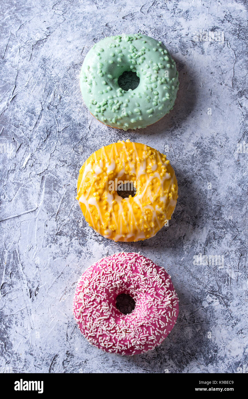 Variety of colorful glazed donuts over gray texture background. Top ...