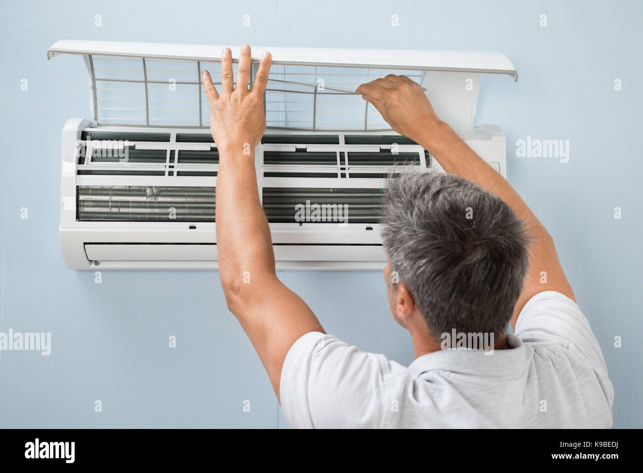 Rear View Of A Man Cleaning Air Conditioning System Stock Photo - Alamy