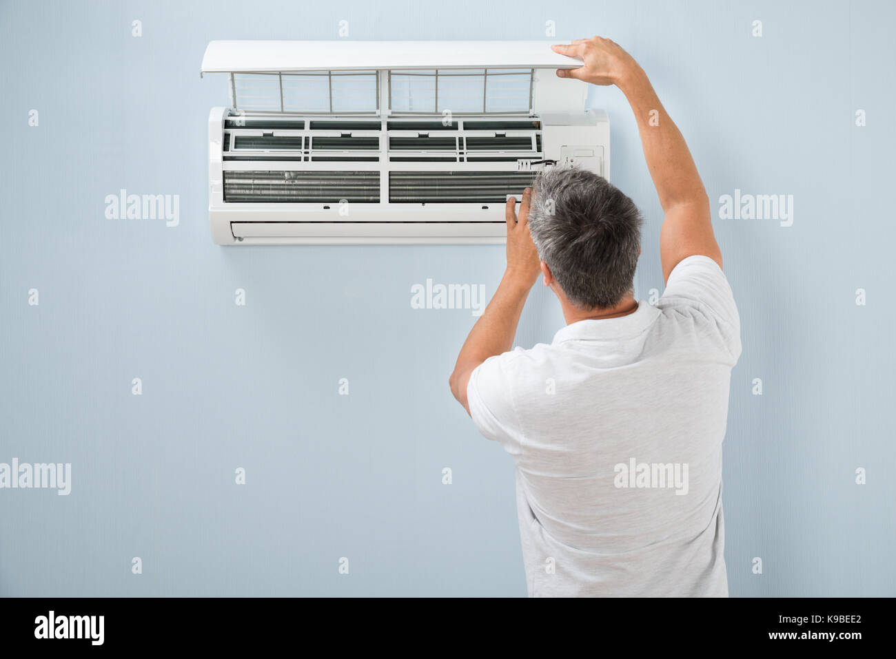 Rear View Of A Man Cleaning Air Conditioning System Stock Photo - Alamy