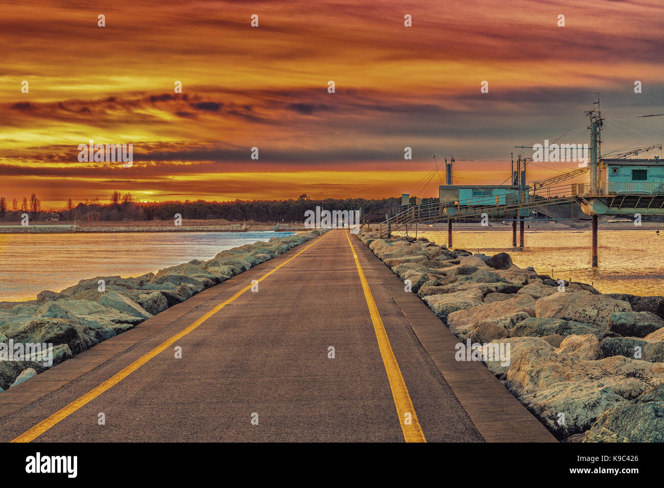 sunset on the pier paved road leading to the beach in Italy Stock Photo ...