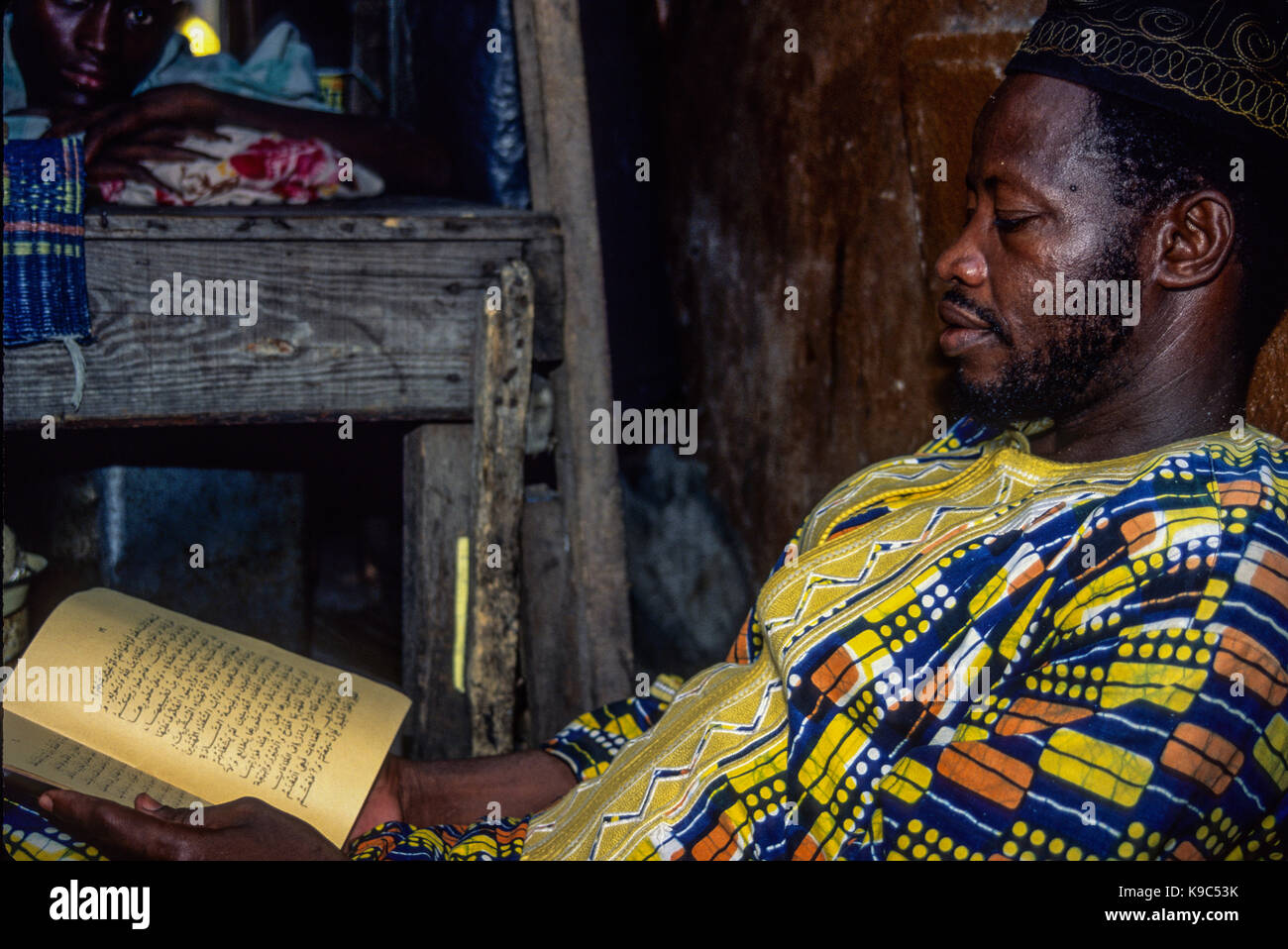 Abidjan, Ivory Coast, Cote d'Ivoire. A Malian from Gao Reading Arabic ...