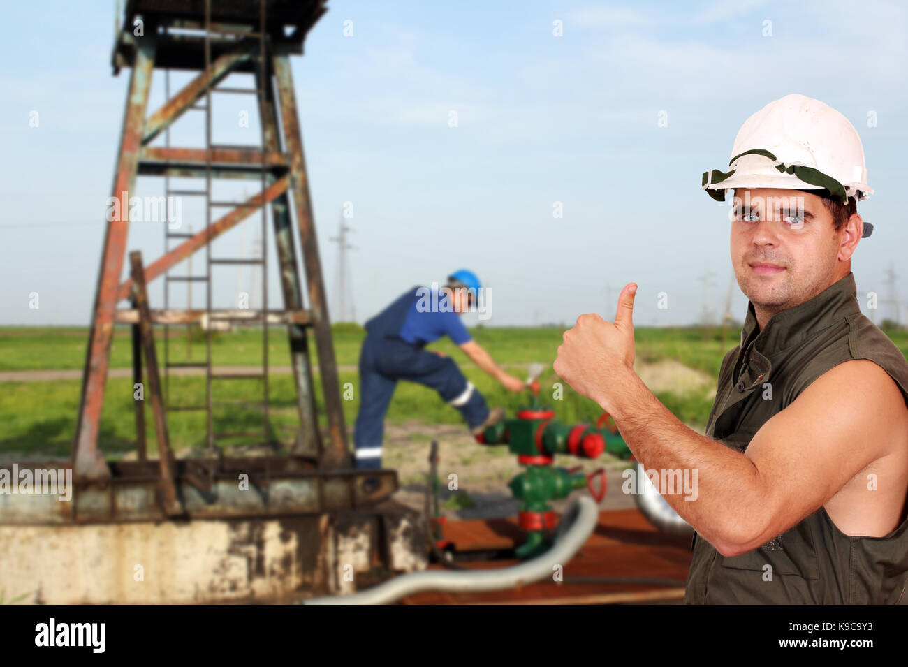 oil worker with thumb up on oilfield Stock Photo - Alamy