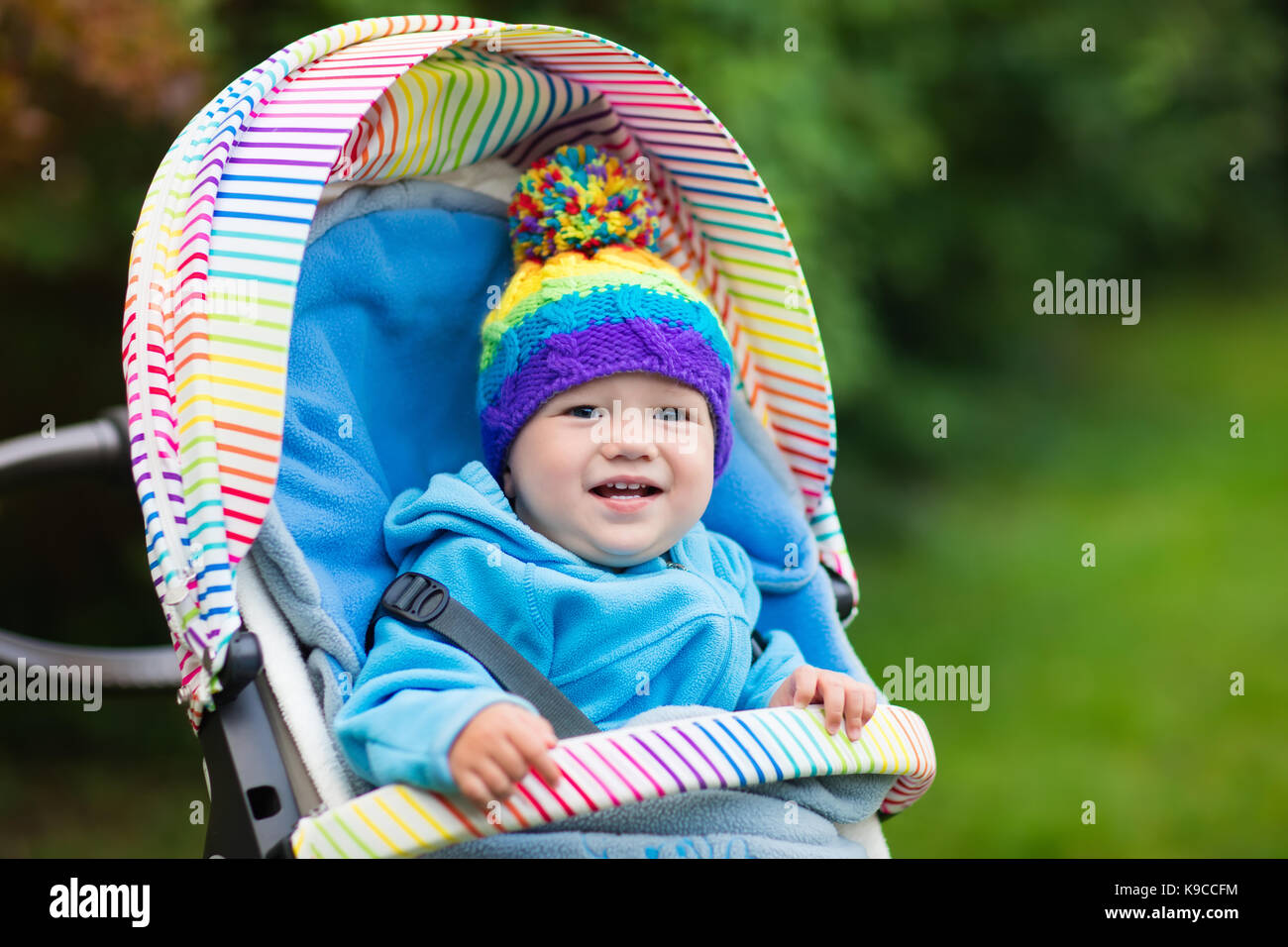 Baby in stroller on a walk in autumn park. Adorable little boy with ...