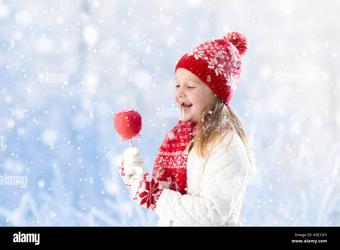 Child eating candy apple on winter fair. Kids eat toffee apples on ...