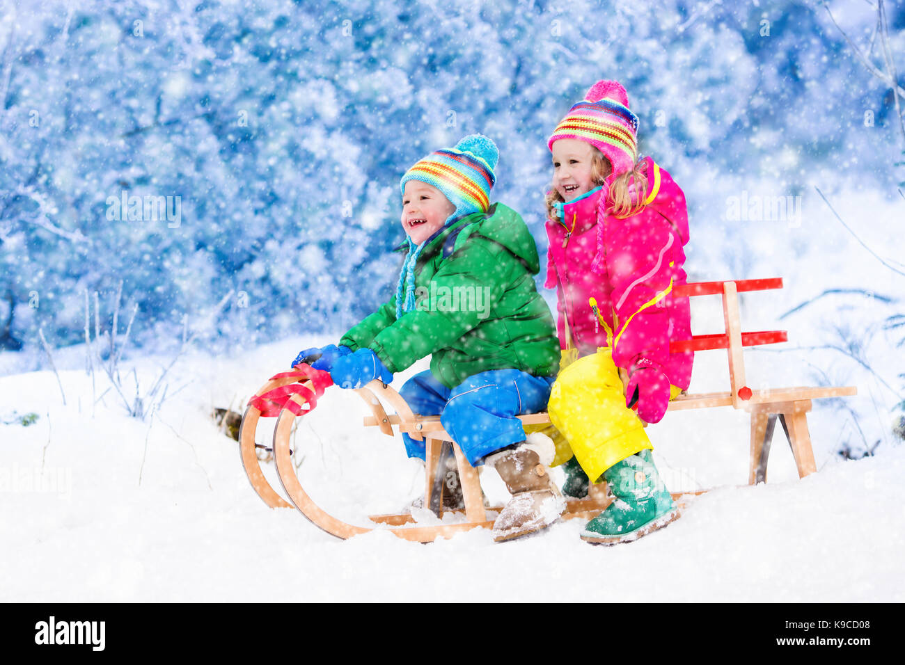 Little girl and boy enjoy a sleigh ride. Child sledding. Toddler kid ...