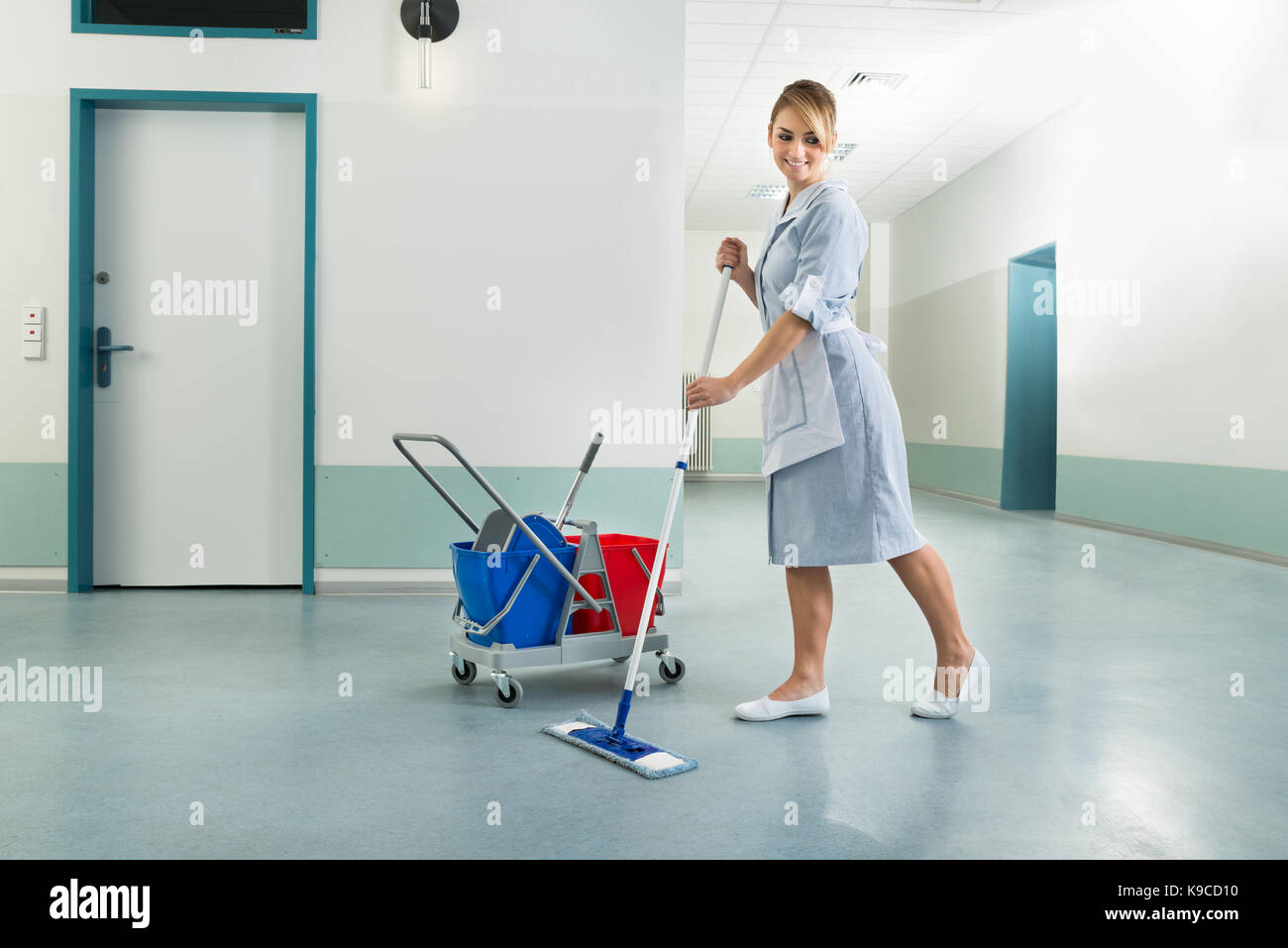 Young Happy Female Janitor Cleaning Floor Of Corridor Pass Stock Photo ...