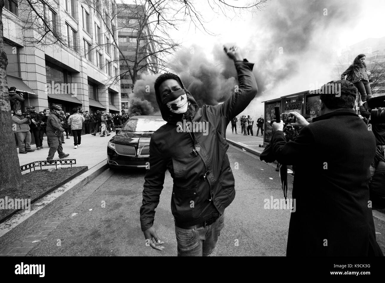 Washington DC, USA - January 20, 2017: A masked demonstrator raises his ...