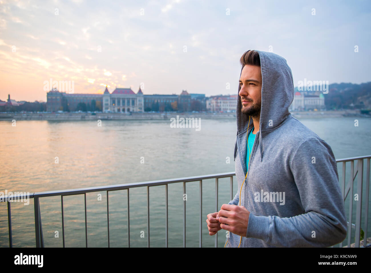 A handsome young man running at the riverside in the sunset Stock Photo ...