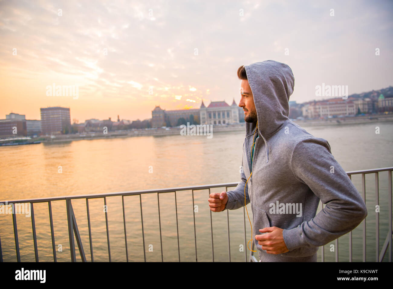 A handsome young man running at the riverside in the sunset Stock Photo ...