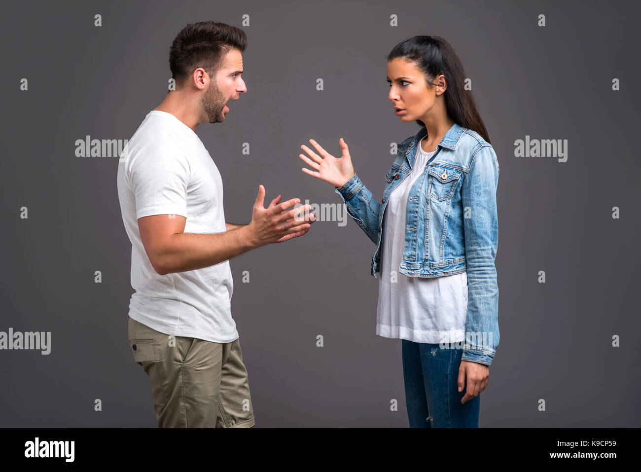 A beautiful young couple standing and arguing in the studio Stock Photo ...
