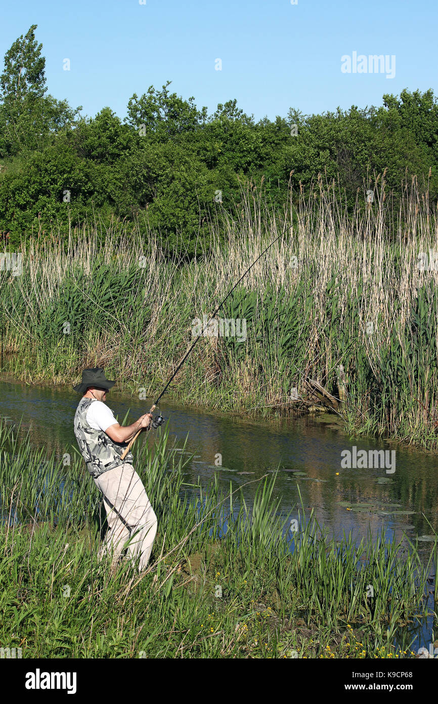 fisherman catching fish on river Stock Photo - Alamy