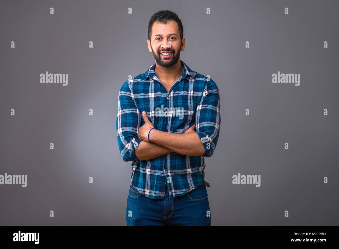 A young black man standing confidently with his arms folded Stock Photo ...