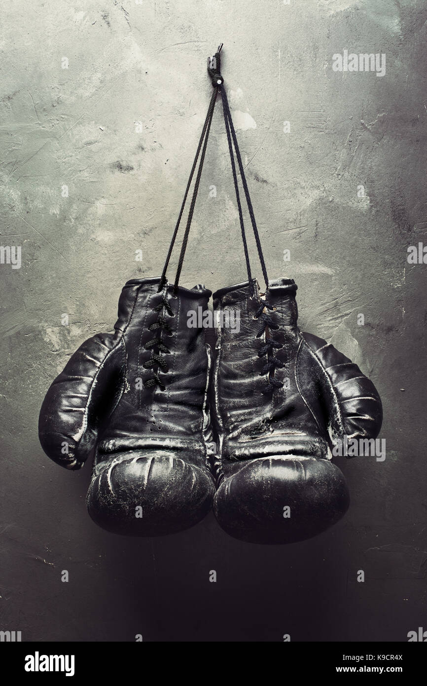 old boxing gloves hang on nail on texturе wall. Retirement concept ...