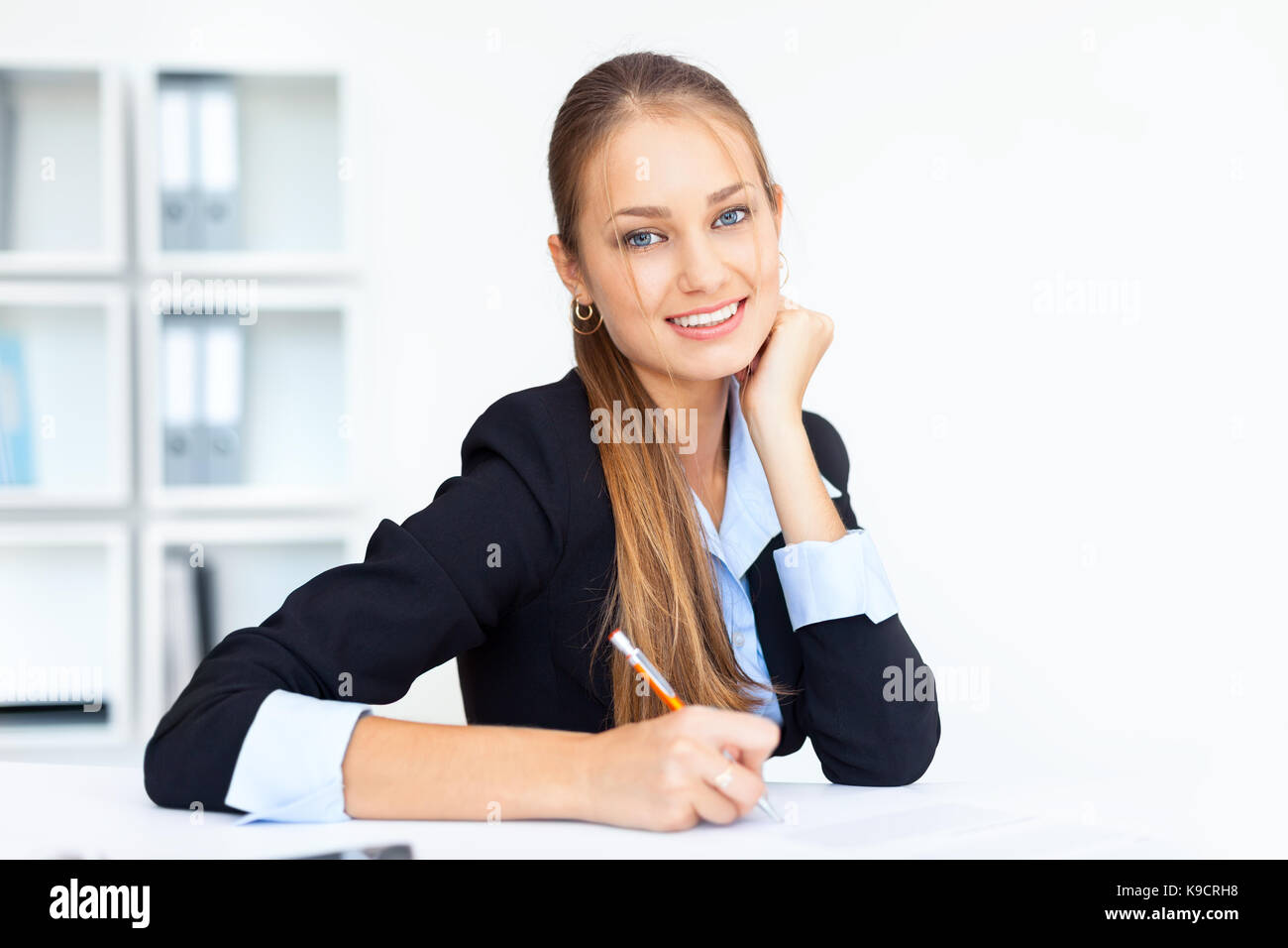 Portrait of a beautiful young business woman doing some paperwork in ...