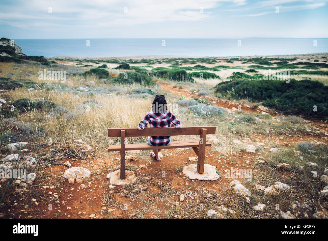 Woman enjoying sea view sitting on a bench in beautiful valley. Relax ...